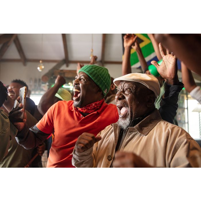 Family - Limpopo - Two men in a crowded bar cheering